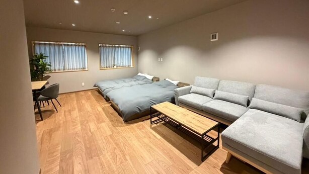Um espaço compacto com sofá, cama, mesa de jantar e mesa de centro.