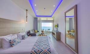Quarto de hotel com uma cama grande, área de estar com vista e varanda.