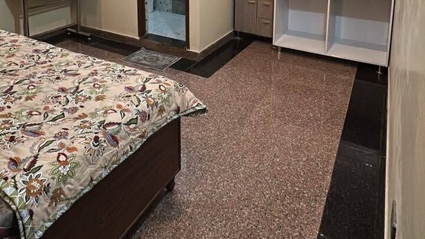 Um quarto com cama, guarda-roupa, escrivaninha e ventoinha no teto.