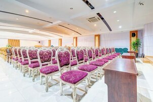 Uma sala de conferências com fileiras de cadeiras e um palanque.
