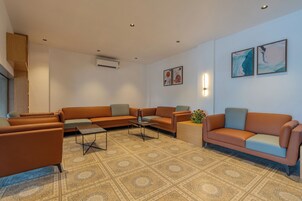 Uma sala de estar moderna com um sofá seccional, uma mesa de centro e um tapete estampado.