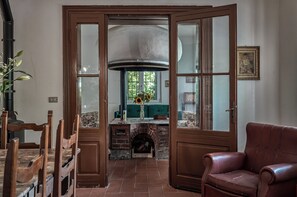 Quarto com lareira, mobiliário de madeira e vista através de uma porta de vidro.