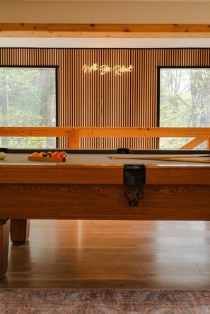 Uma mesa de bilhar com fundo de madeira e uma placa com o nome 'North Star Retreat'.