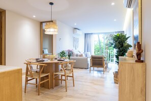 Uma sala de estar moderna com área de jantar, uma grande janela com cortinas e um ventilador de teto.