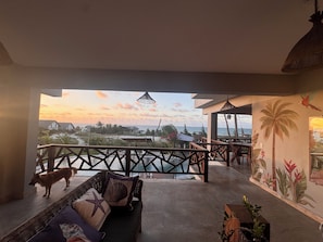 Uma varanda com vista para o mar e um cão.