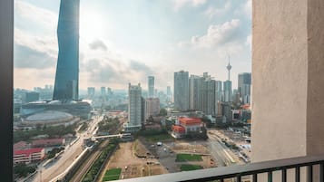 Paisagem urbana com edifícios altos, uma torre imponente e um estádio.