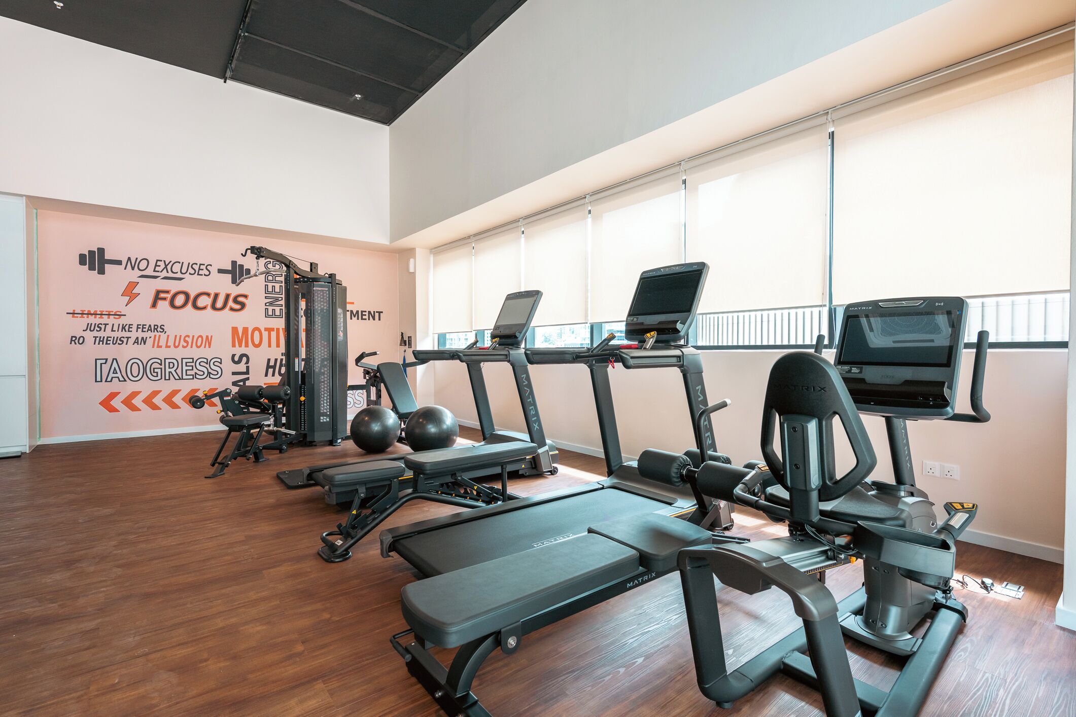 Uma academia com esteiras, aparelhos de musculação e bolas de exercício.