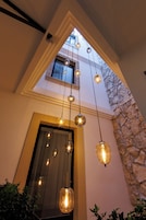 Um interior moderno com clarabóia, luminárias pendentes e uma parede de pedra.