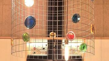 Uma cozinha com uma ilha central, um lustre com esferas de vidro coloridas e um fogão.
