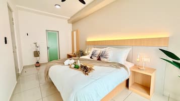 Quarto moderno com cama, mesa de cabeceira e ventilador de teto.