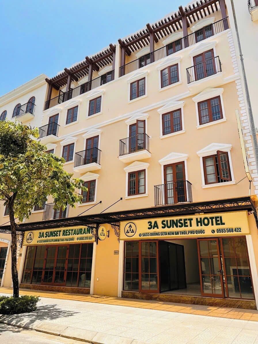 Um edifício de vários andares com um restaurante no térreo e um letreiro de hotel.