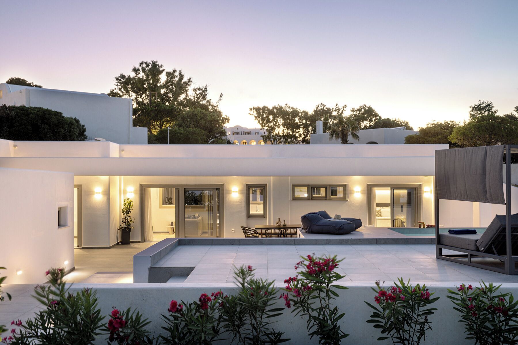 Uma casa moderna com um pátio, área de estar externa e piscina.