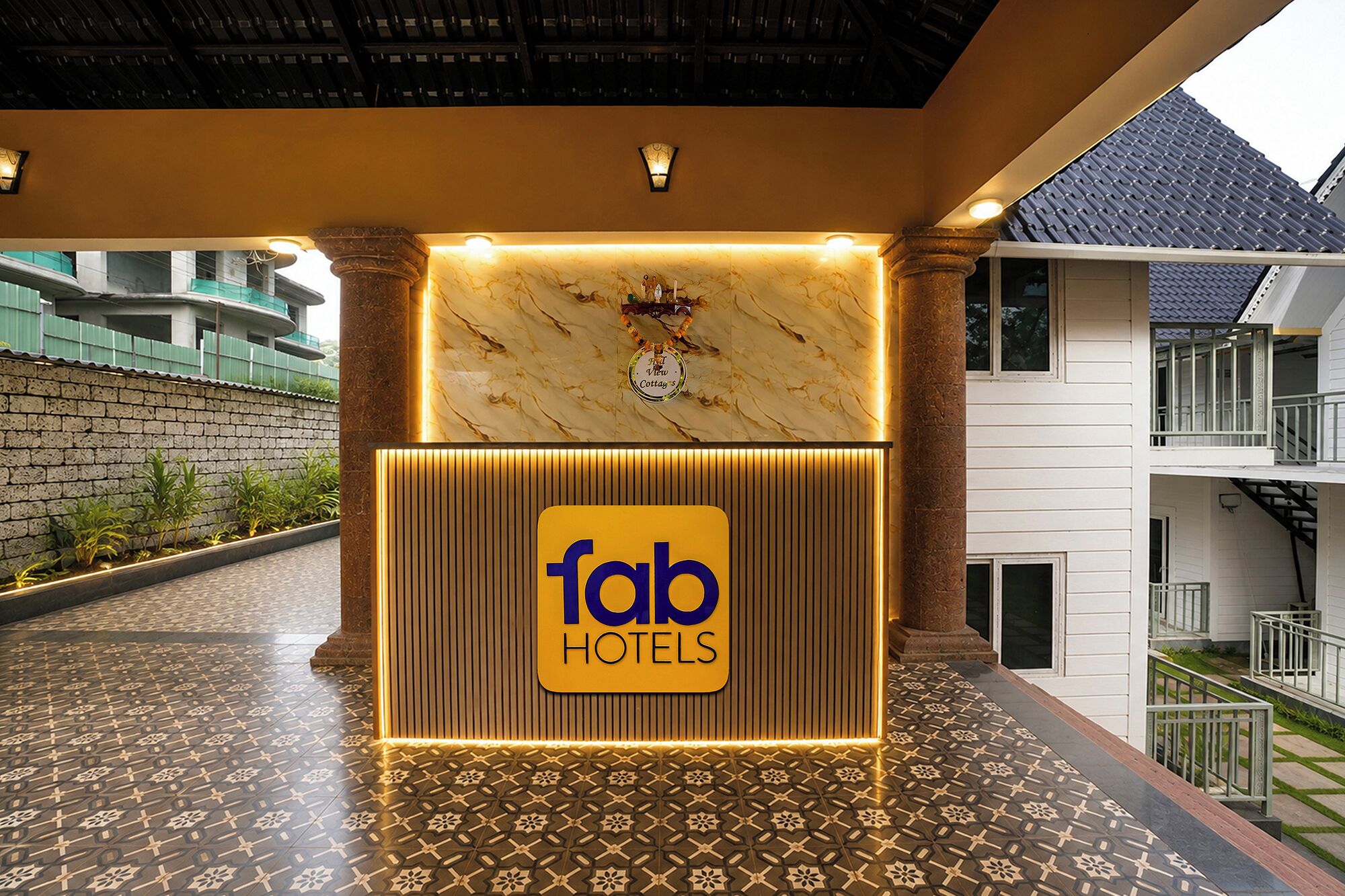 Uma área de recepção com parede de mármore e sinalização para Fab Hotels.