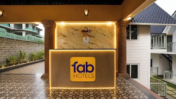 Uma área de recepção com parede de mármore e sinalização para Fab Hotels.