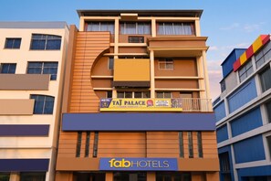 Edifício de vários andares com uma placa indicando 'Taj Palace', identificando-o como um hotel.