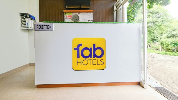 Uma receção com um letreiro para 'fab hotels' e o sinal 'Recepção' em cima.