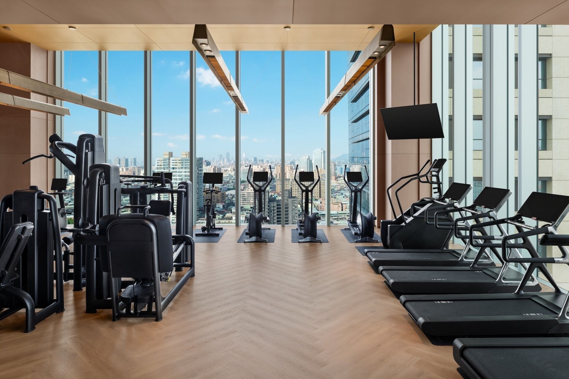 Uma academia com equipamentos de ginástica e vista para a cidade.