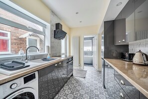 Um frigorífico, um micro-ondas, um forno, uma placa de cozinha 