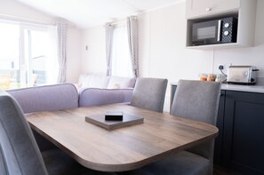 Uma cozinha moderna com micro-ondas, torradeira e potes com condimentos.