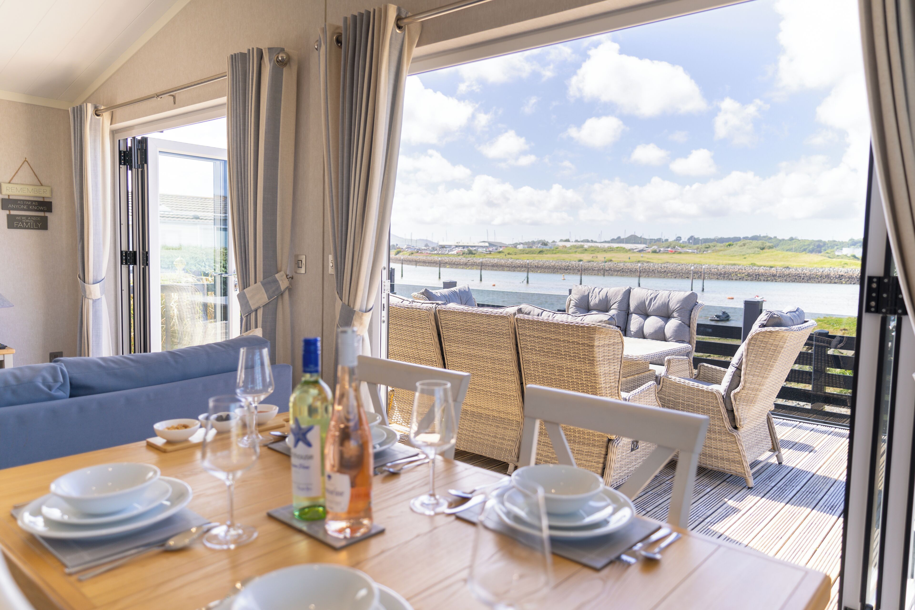 Espaço de refeições com uma mesa posta para dois, com vista para a frente do mar.