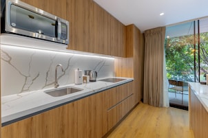 Uma cozinha moderna com bancada de mármore, eletrodomésticos de aço inoxidável e armários de madeira.