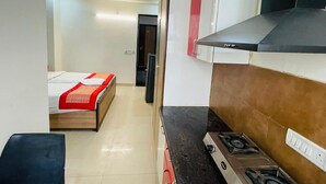 Uma cozinha compacta com fogão a gás, micro-ondas e armários.