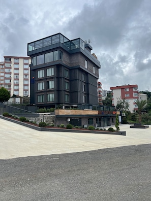 Um edifício moderno com fachada de vidro, várias janelas e telhado plano.