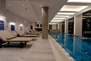 Piscina com espreguiçadeiras e design de interiores moderno.