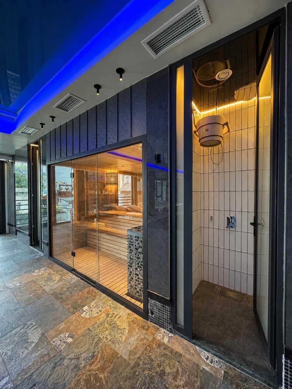 Um interior moderno com divisória de vidro, um banco de madeira e uma parede revestida de azulejos.