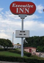 Placa do Executive Inn com mensagem de boas-vindas e informações sobre TV a cabo e WiFi.