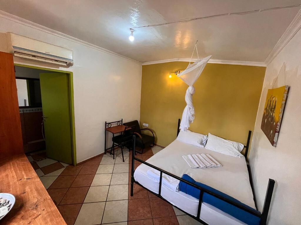 Um quarto com uma cama, uma escrivaninha e uma cadeira.