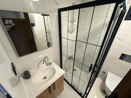 Apartamento básico | Banheiro | Toalhas de banho, sabonete, shampoo, papel higiênico