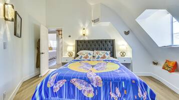 Quarto com uma cama grande, um claraboia e vista para o quarto vizinho.