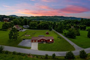 Uma propriedade extensa com vários edifícios, um gramado bem cuidado e uma vista panorâmica de colinas ondulantes.