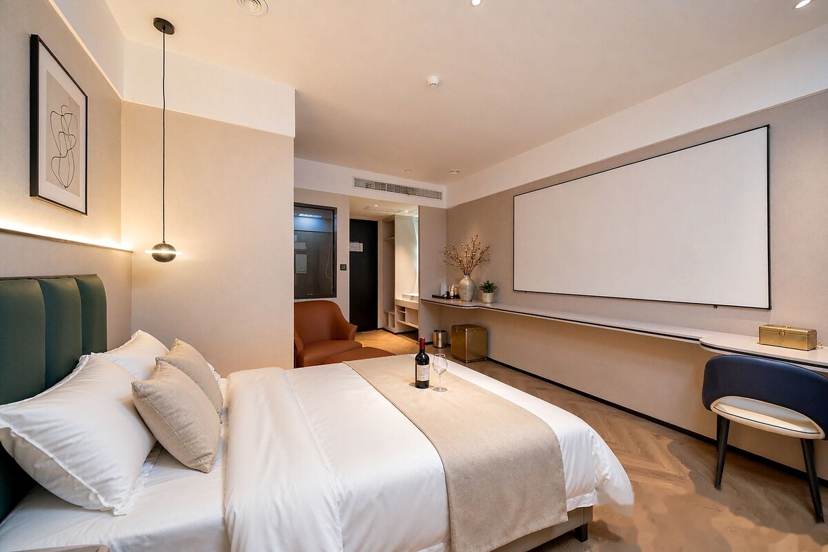 Quarto de hotel moderno com uma cama, uma escrivaninha e uma tela grande na parede.