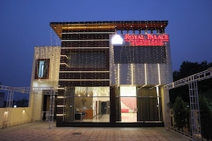 Um hotel com fachada moderna, sinalização iluminada e entrada acolhedora.