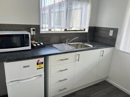 Uma cozinha com micro-ondas, pia e frigorífico.