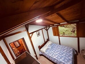 Quarto com cama, janela e vista para o exterior.