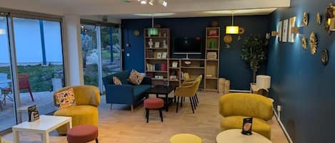 Uma sala de estar moderna com um sofá, cadeiras, uma mesa de centro e uma televisão.