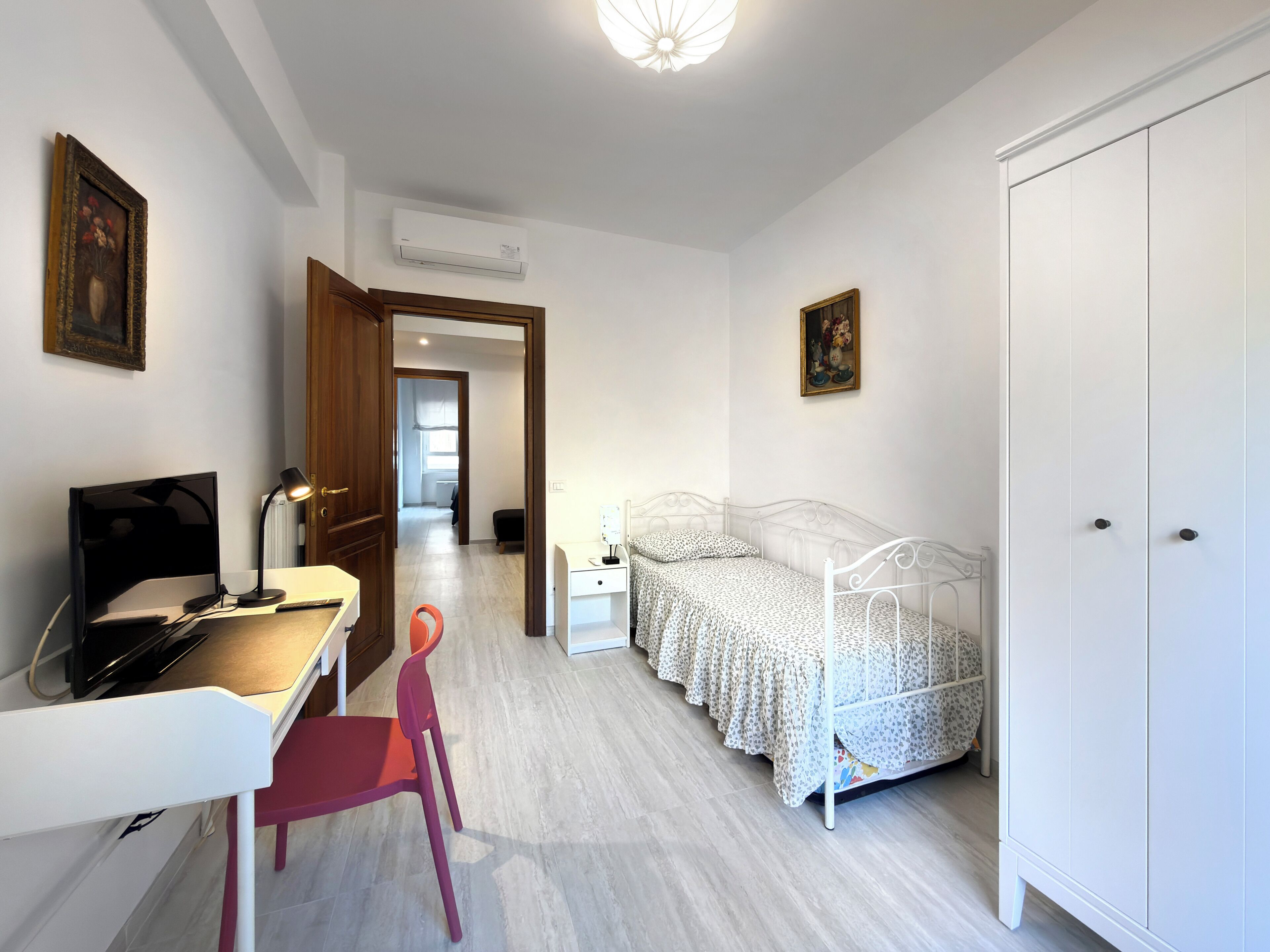 Quarto com cama, escrivaninha, cadeira e guarda-roupa.