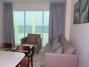 Uma sala de estar moderna com sofá, poltrona e mesa de jantar.