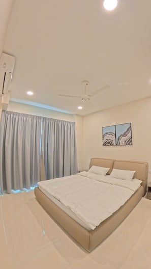 Um quarto moderno com cama, cortinas, ventilador de teto e obras de arte na parede.