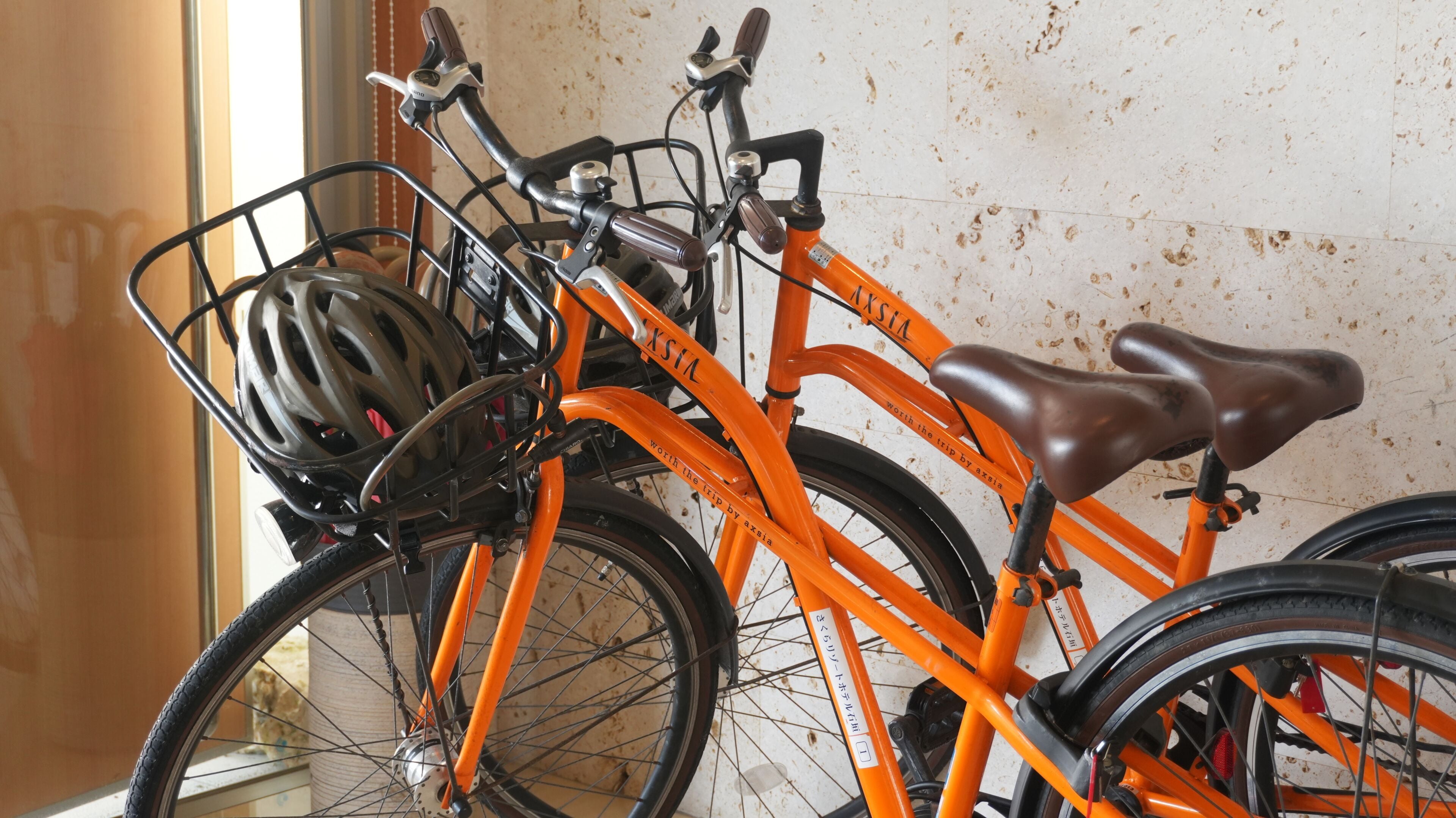 Duas bicicletas estacionadas em ambiente interno, com um capacete em uma e um assento na outra.