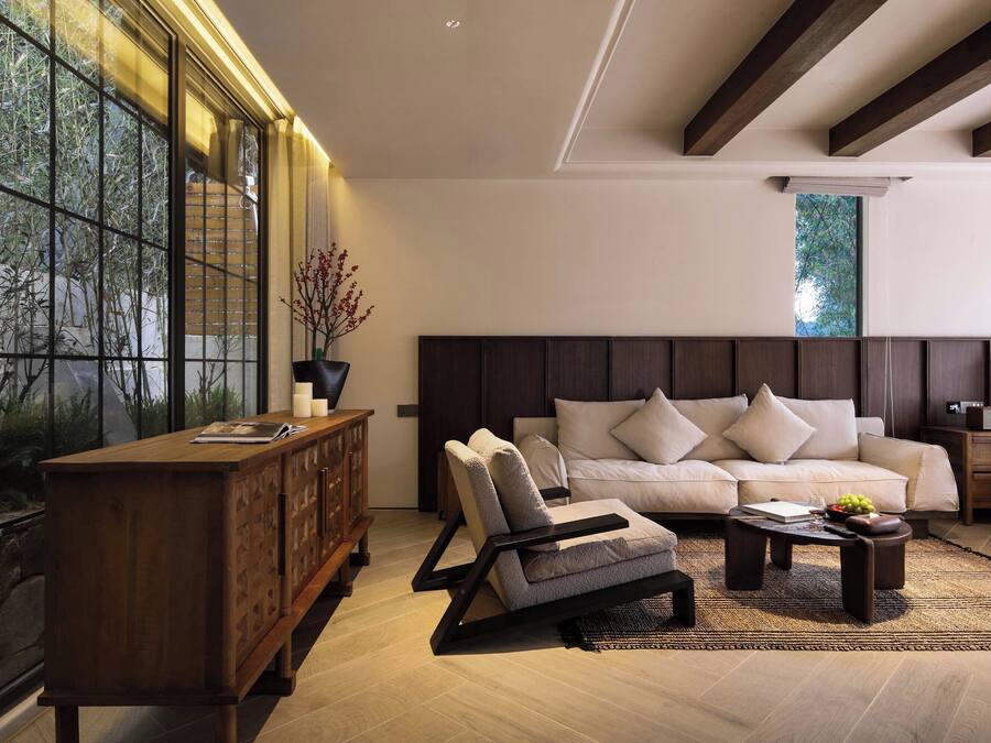 Uma sala de estar moderna com um sofá, uma mesa lateral de madeira e uma mesa de centro.