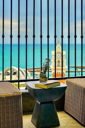 Uma varanda com vista para o oceano e um campanário.
