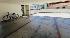 Uma área externa ampla com uma bicicleta encostada na parede.