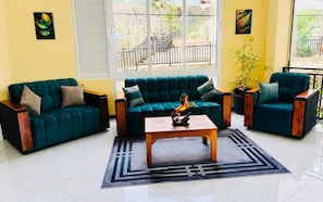 Uma sala de estar com um sofá, uma mesa de centro e um vaso de planta.