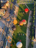 Vista aérea de um cruzamento urbano com múltiplas rotatórias e uma área central gramada.