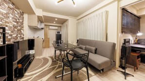 Uma sala de estar moderna com um sofá, uma mesa de jantar de vidro e uma televisão.