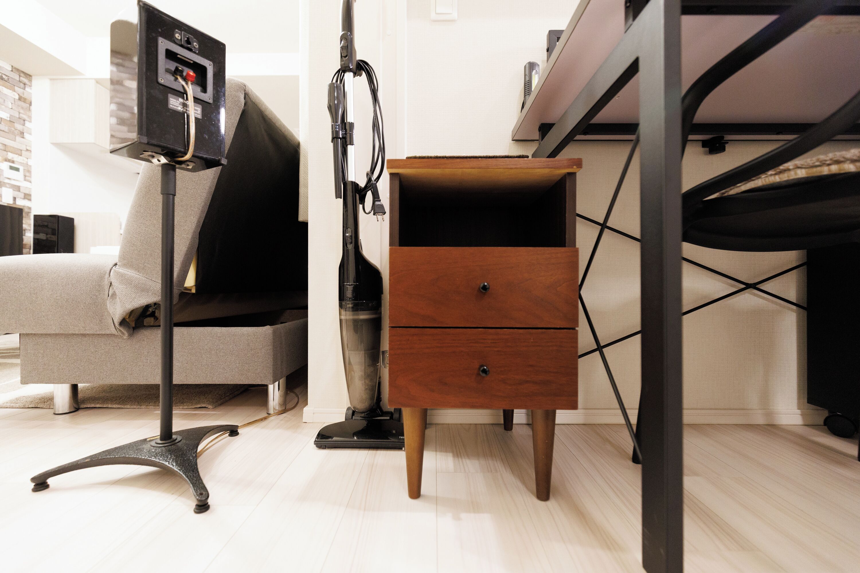 Quarto compacto com uma cama, uma escrivaninha e um pequeno armário de madeira.